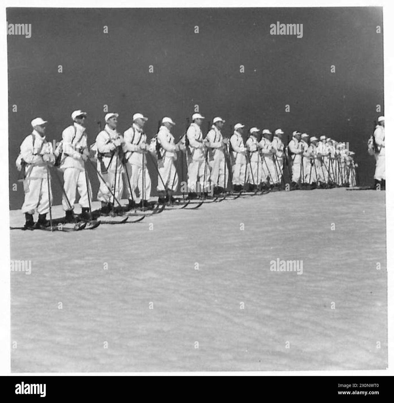 Ski-trained troops are lined up on a slope preparing to descend ...