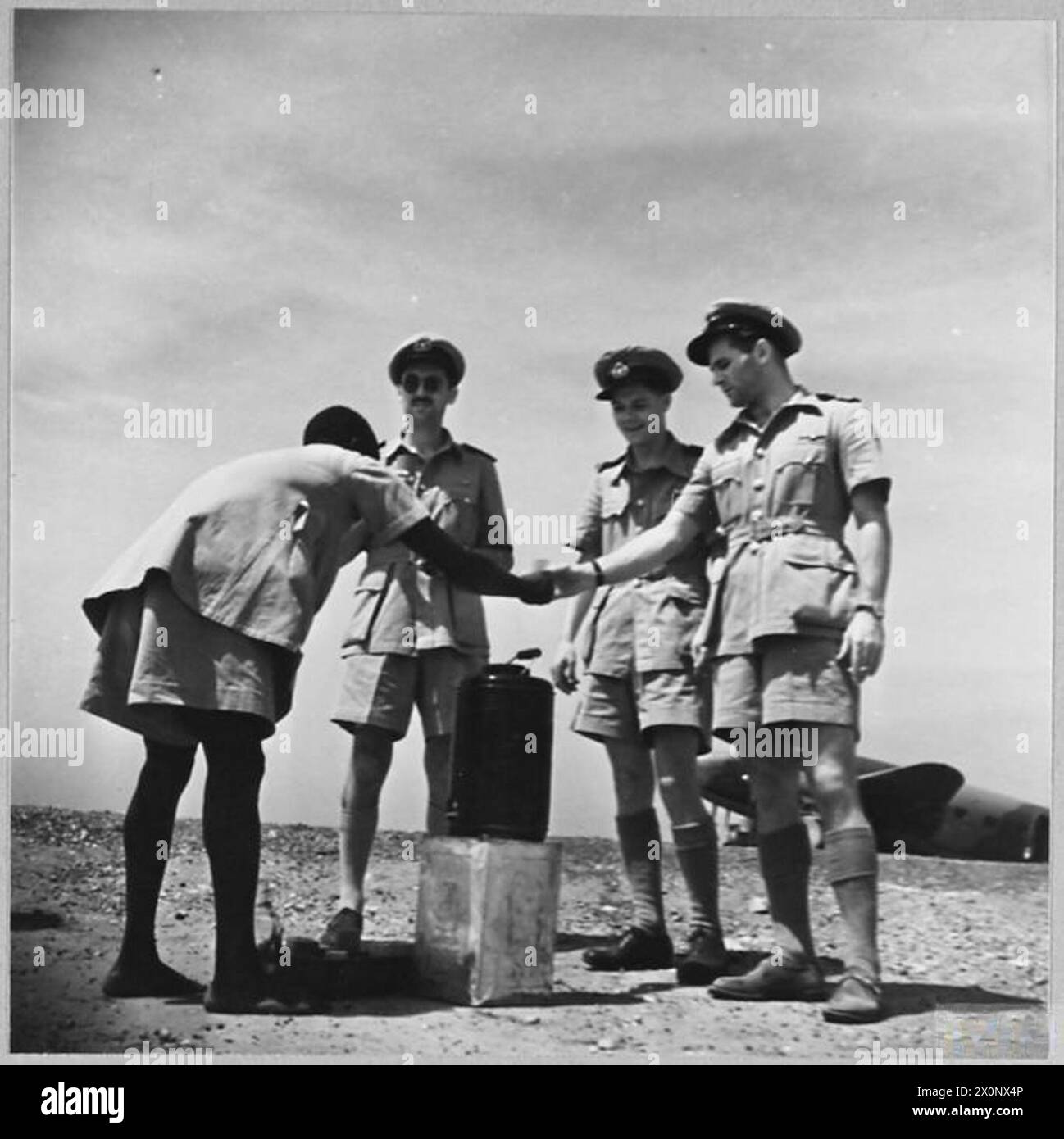 A native boy offers drinks from a thermos to the crew of a BOAC ...