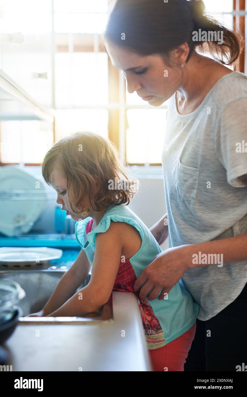 Washing, dishes and mom with girl in home for chores, teaching and ...