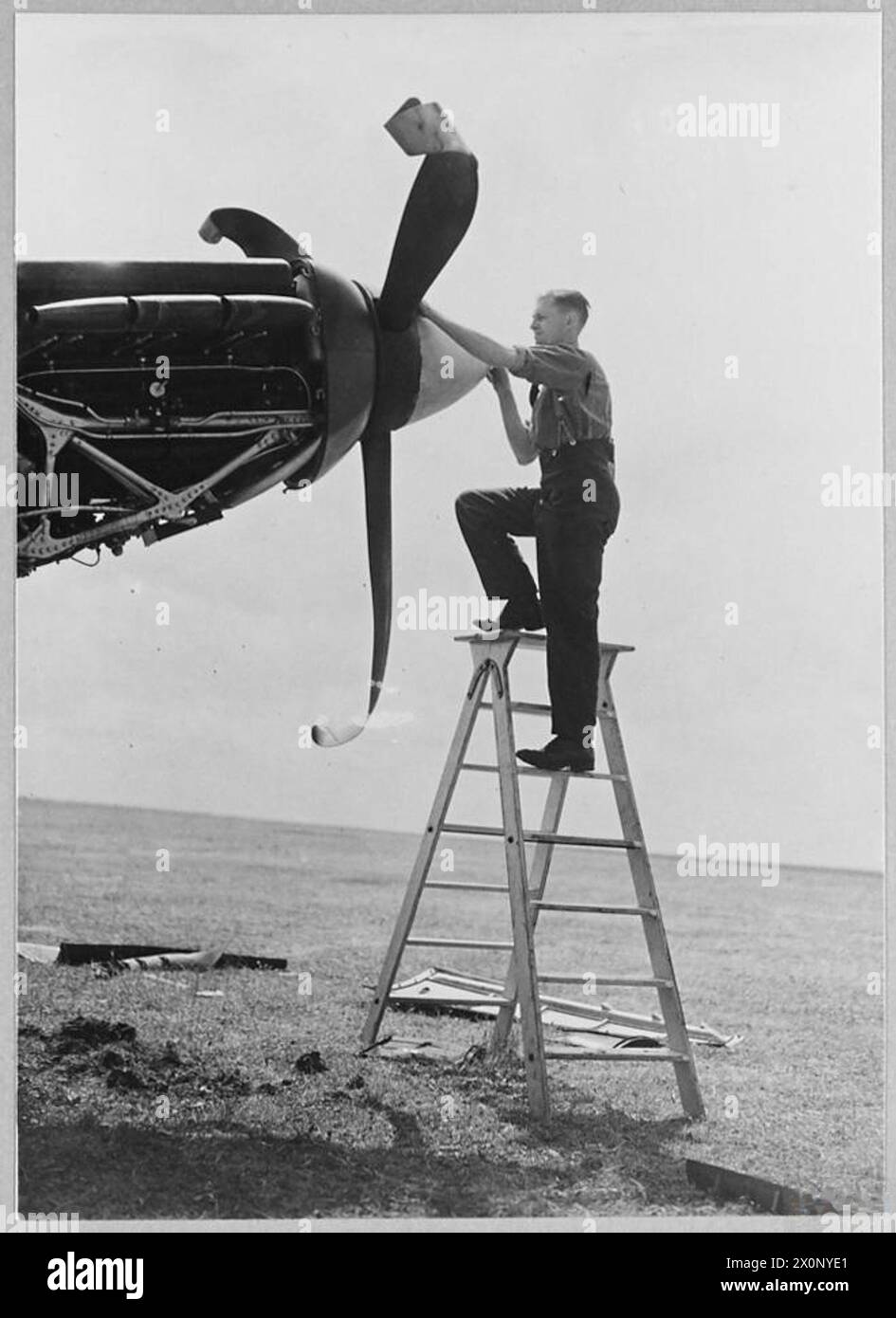 RAF FIGHTER COMMAND 1940 - An airman on a step ladder examines the nose ...
