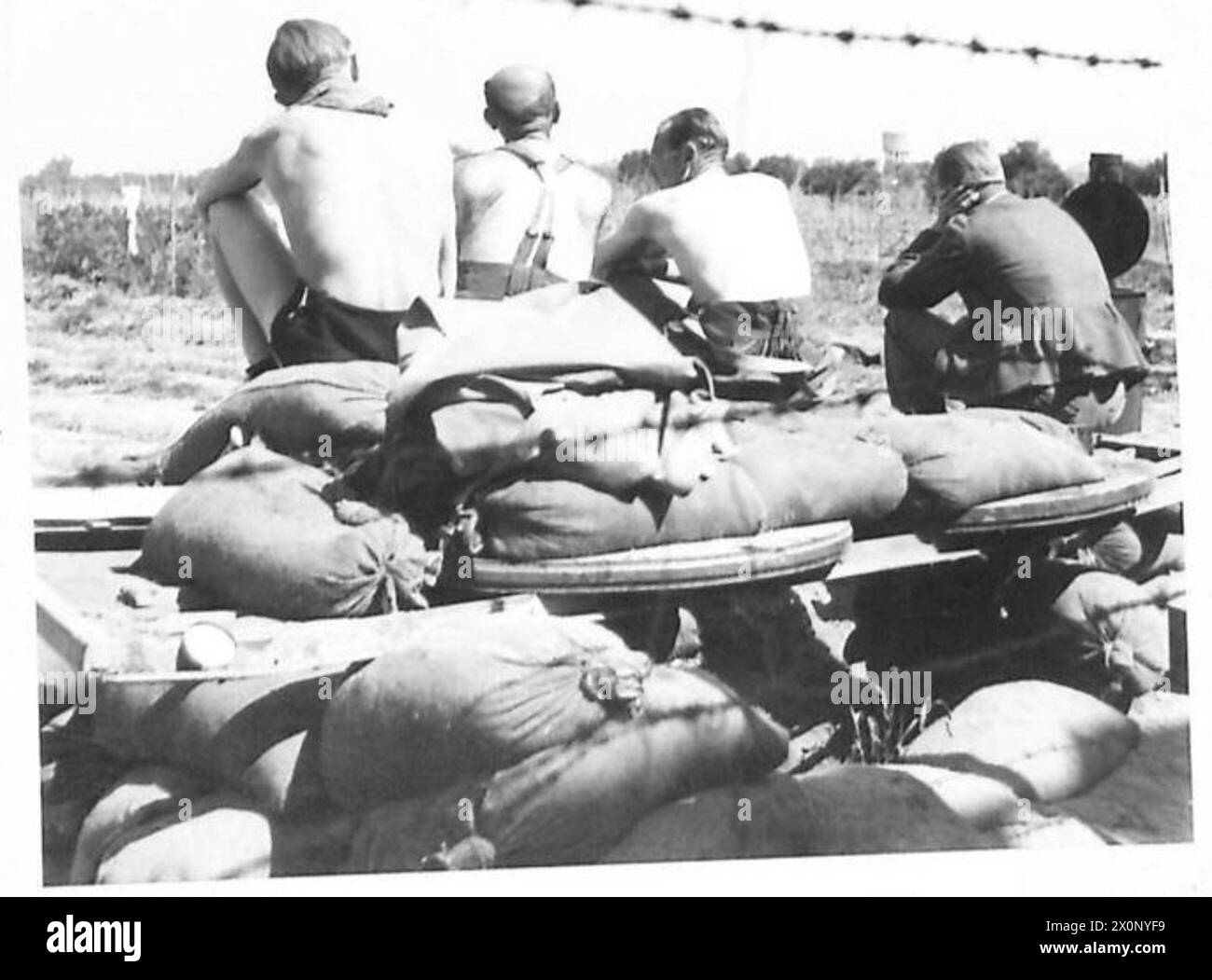 Prisoners are seen sunbathing inside a barbed wire enclosure during ...