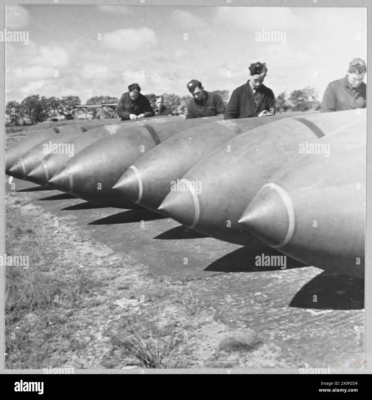 Photograph showing RAF armourers preparing a new torpedo-shaped 12,000 ...
