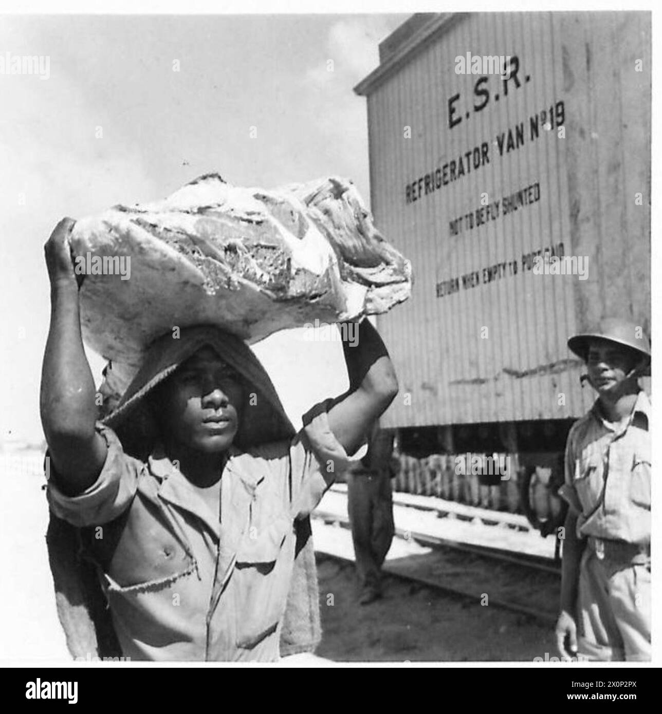 FEEDING THE TROOPS IN THE WESTERN DESERT - Mauritius soldiers carrying the meat to the despatch ...