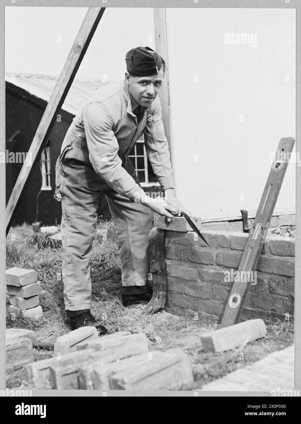 Leading Aircraftman L.P. Williams is shown performing bricklaying as ...