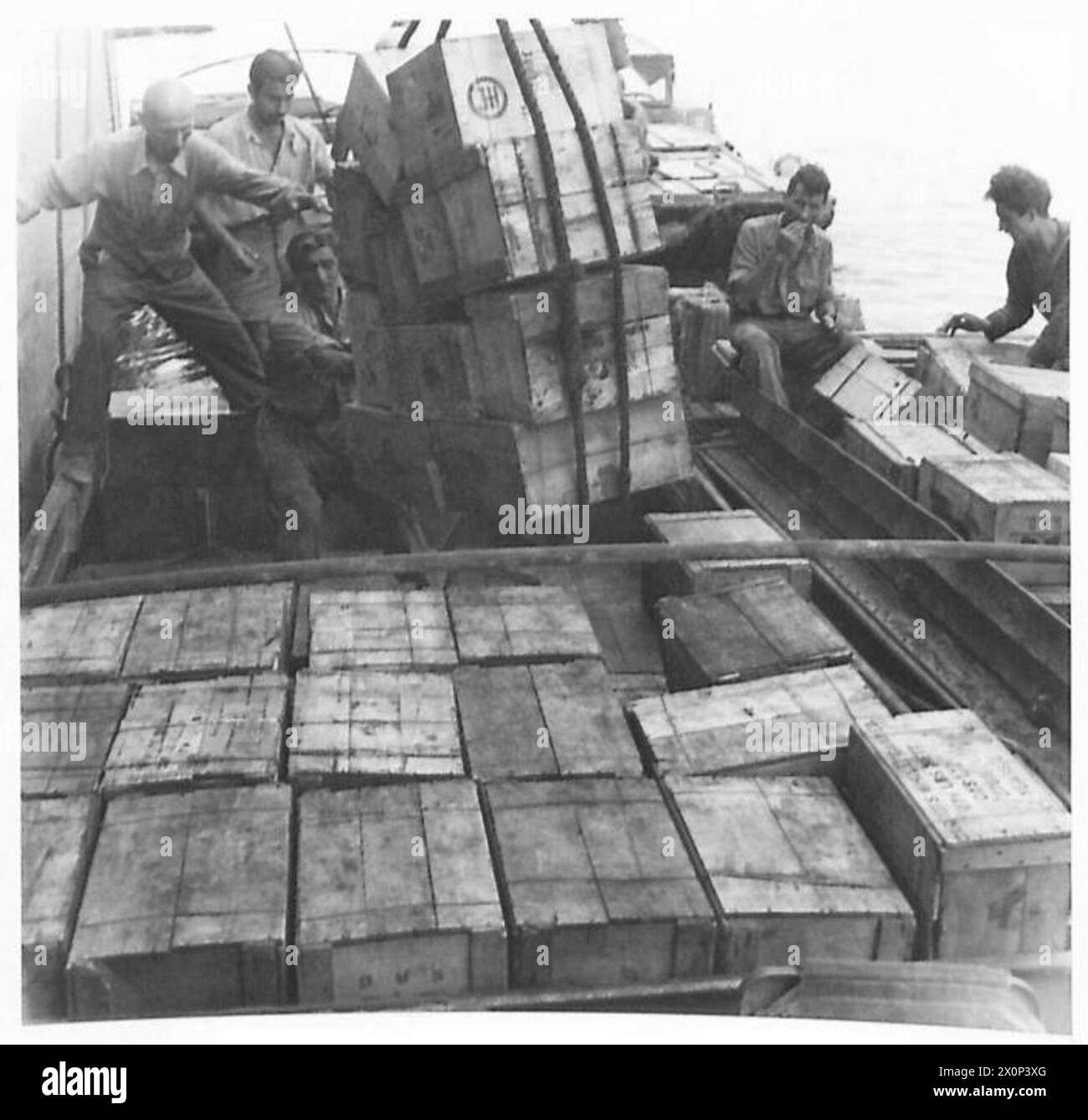 Dukws pull alongside a Liberty ship at Ancona to load naval stores and ...