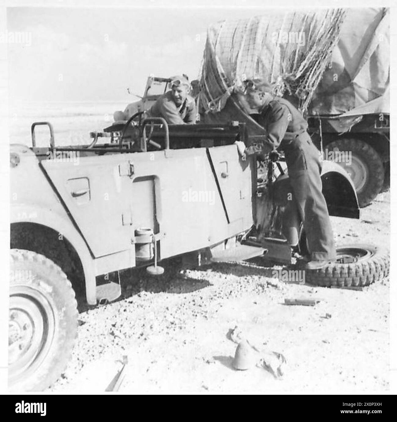 A British Army salvage party inspects a captured German car in forward ...