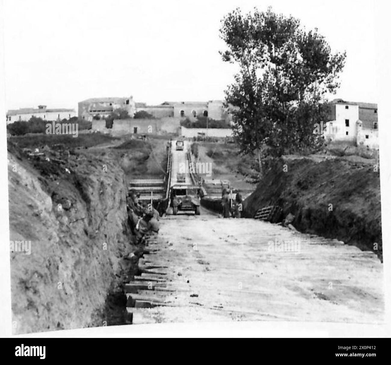 A floating pontoon Bailey bridge is shown at the Fifth Army front in Italy with vehicles ...