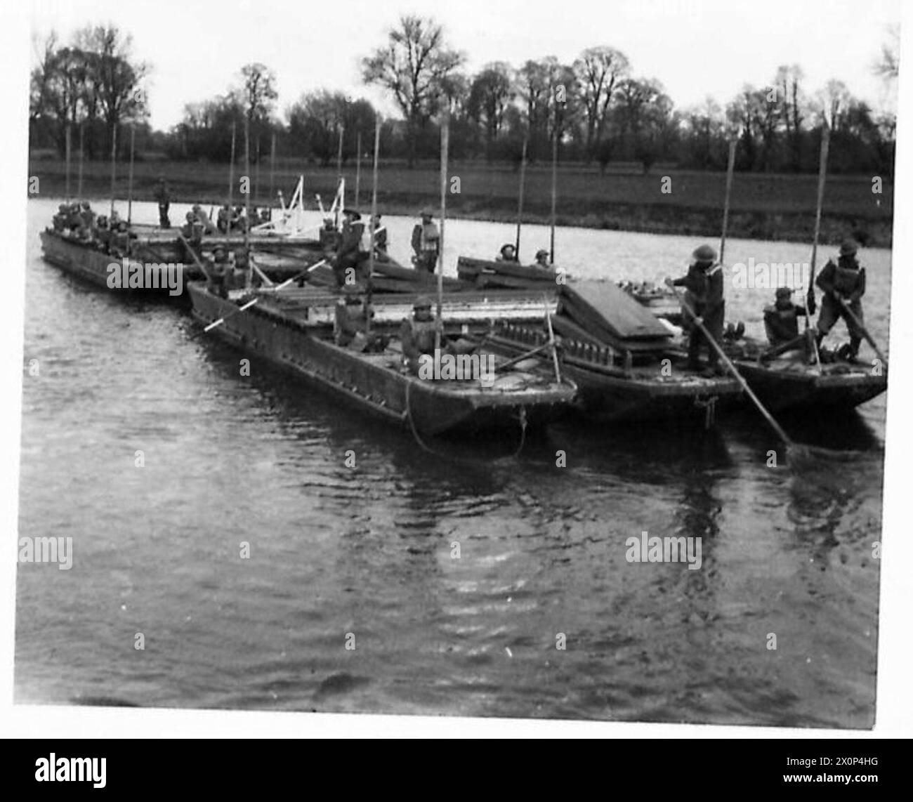 A pontoon bridge is being constructed with bridging rafts maneuvered ...