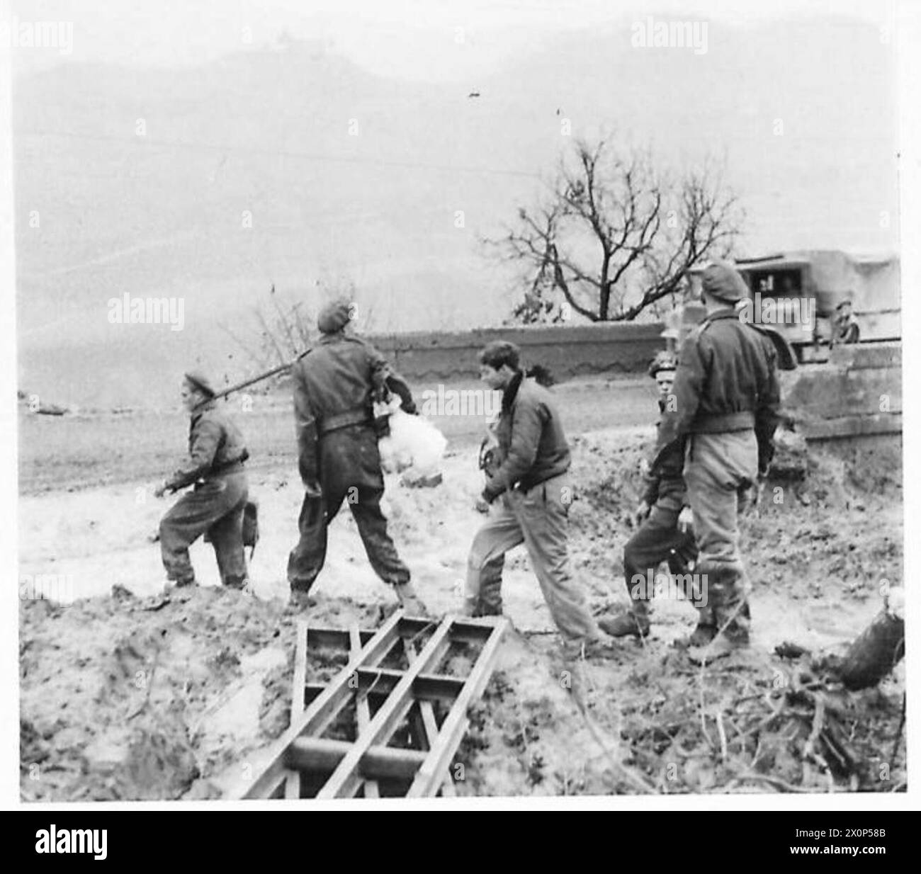 FIFTH ARMY : VARIOUS - Capt. Smith is ecorted through the mud to the ...