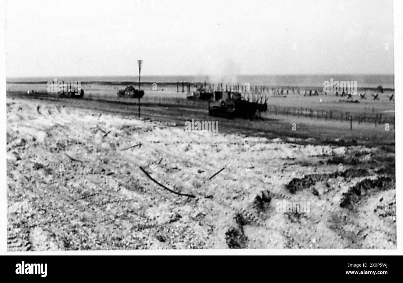 A Sherman tank advances on the beach while Churchills follow to clear ...