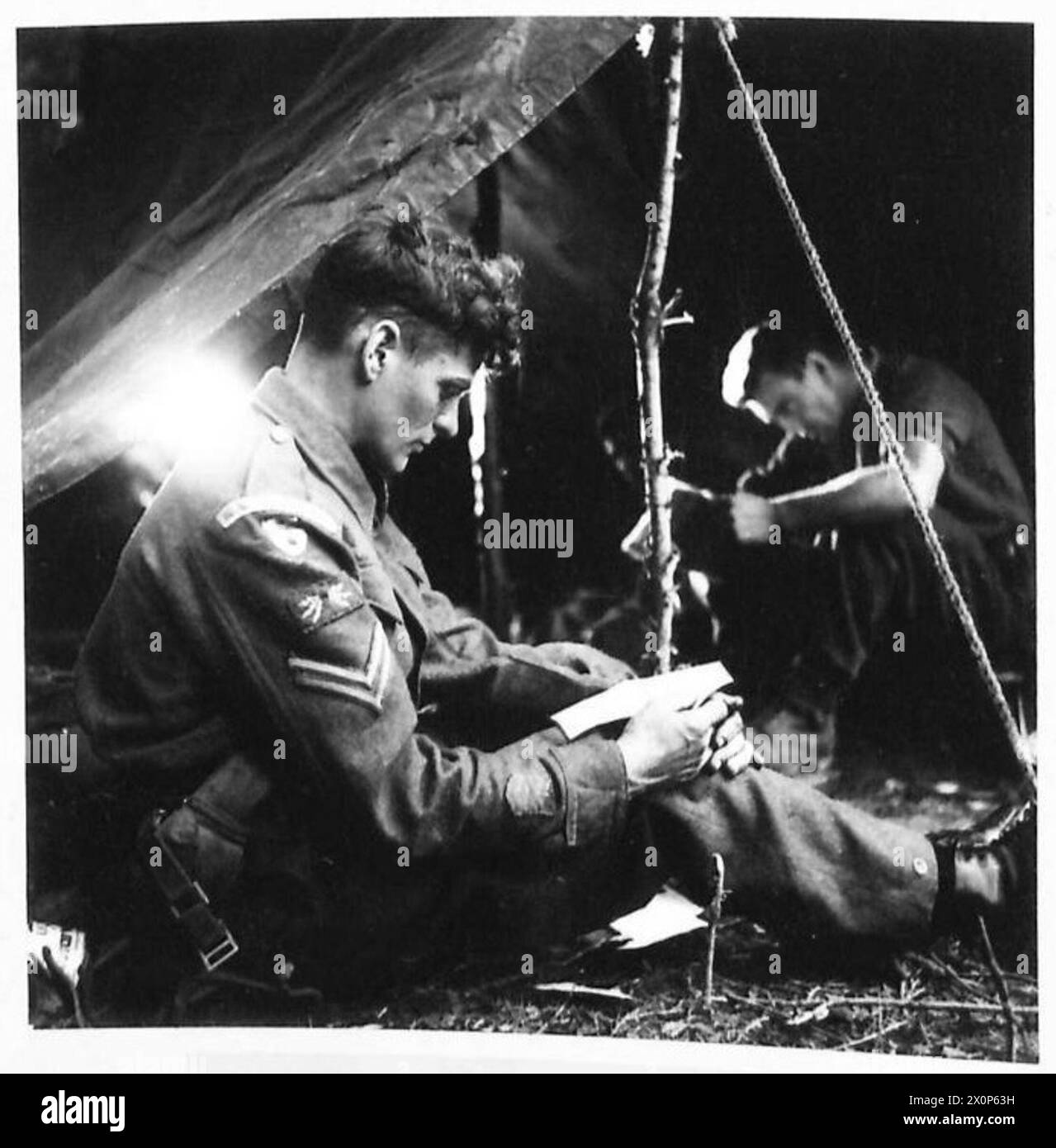Corporal Walmsley of a Churchill tank crew reads letters at the ...
