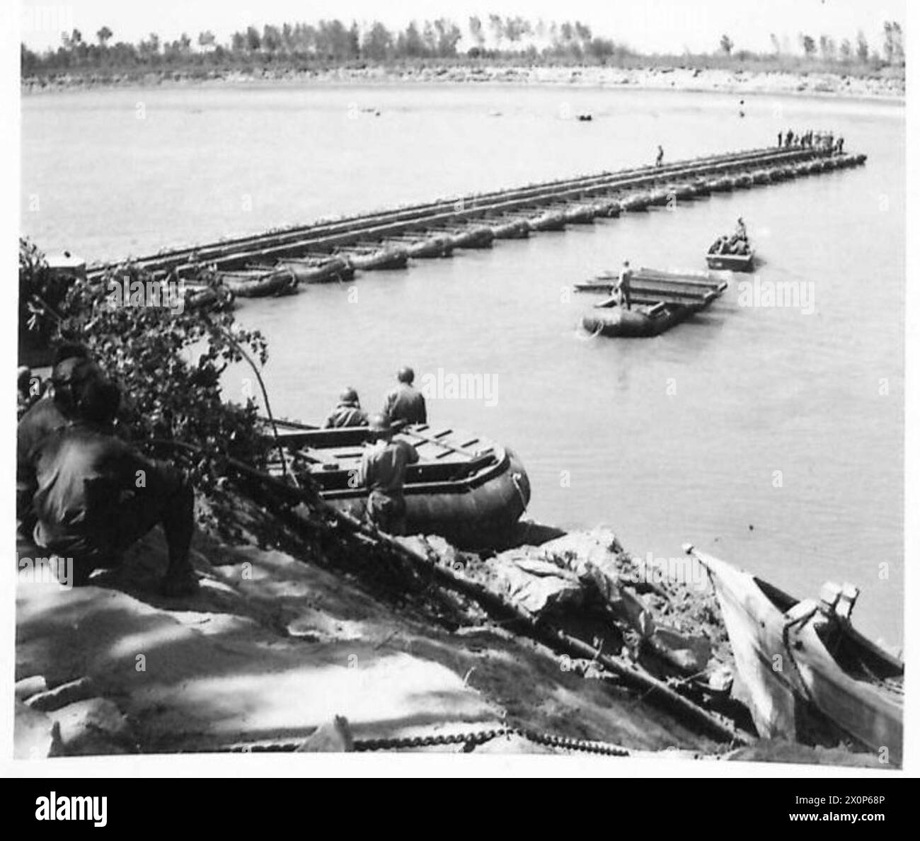 A rubber pontoon is towed to the end of a temporary bridge by the Fifth ...