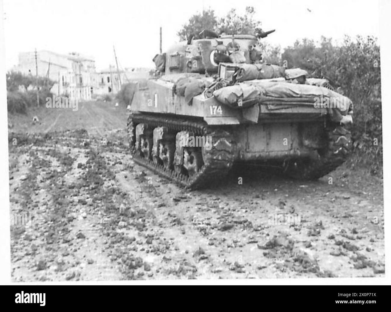 A tank of the 12th Canadian Tank Regiment is positioned to advance on ...