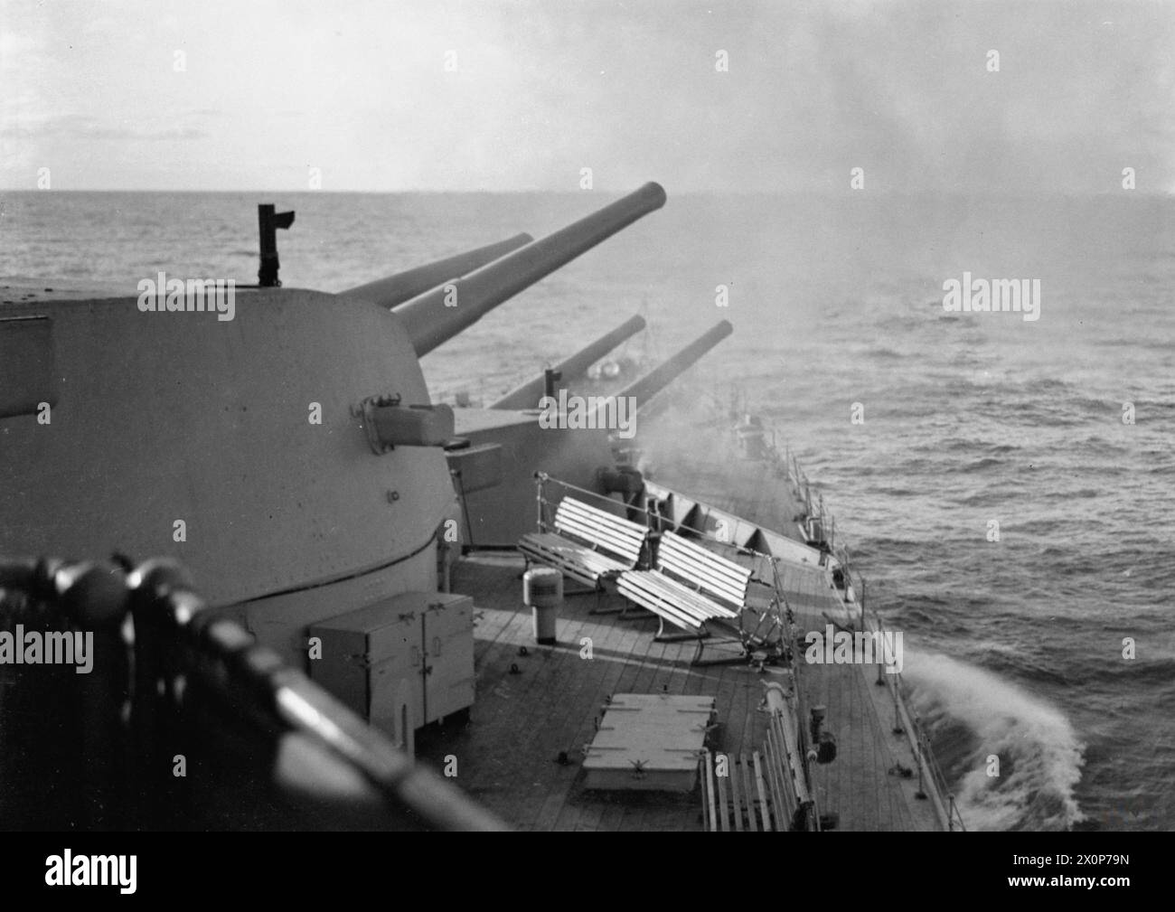 HMS Shropshire, a British cruiser, is photographed firing 8-inch guns ...