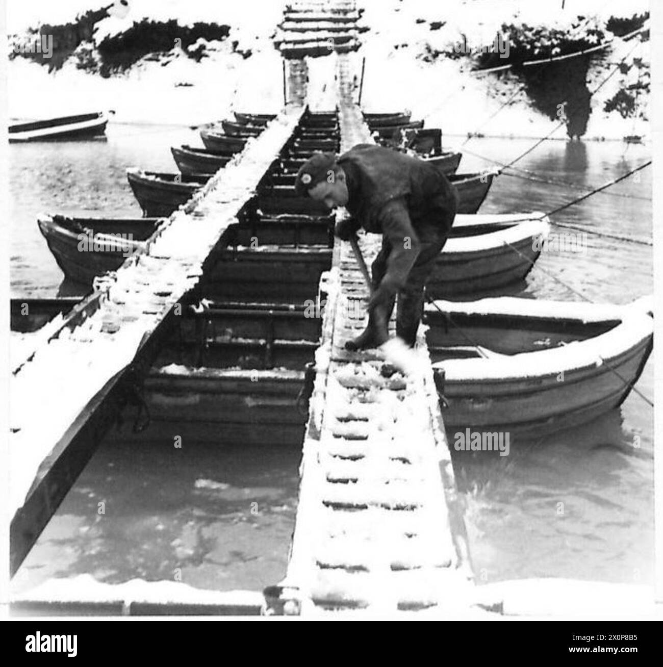 Fifth Army soldiers clear snow from a pontoon bridge over the River ...