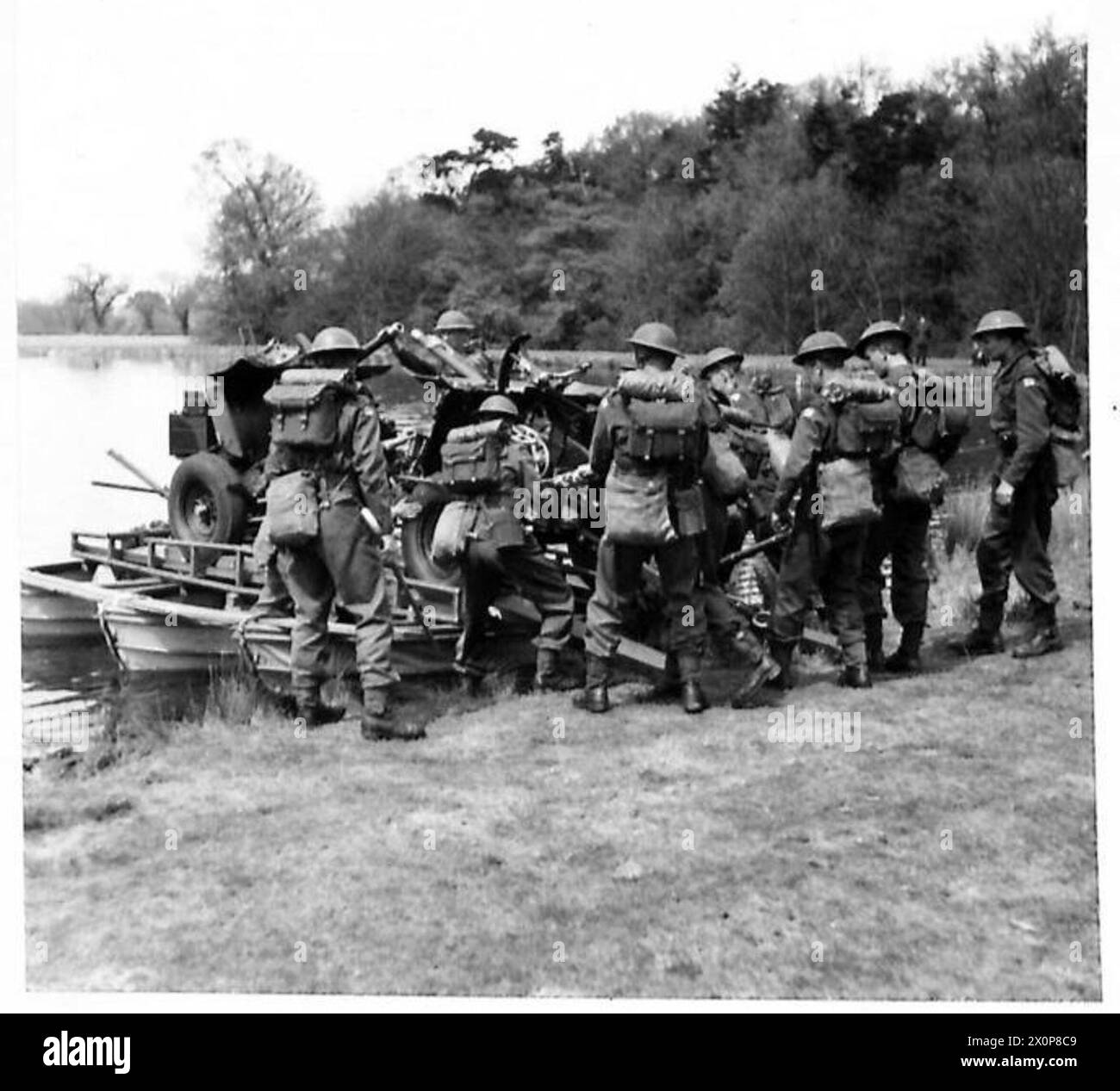 Two anti-tank guns are loaded onto assault boats prepared for a river ...
