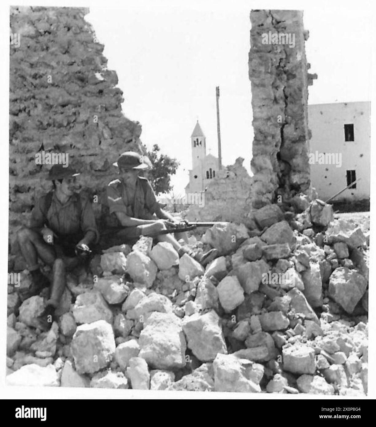 British soldiers resting on rubble in the town of Tobruk during the ...