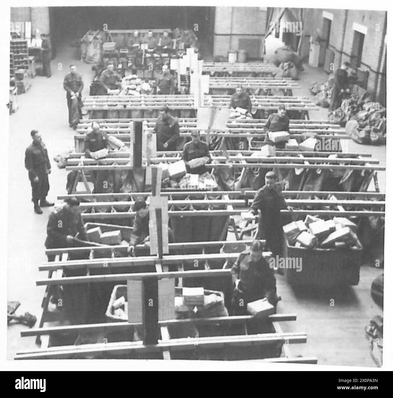 Men of the Army Postal Service sort and organize parcels for delivery ...
