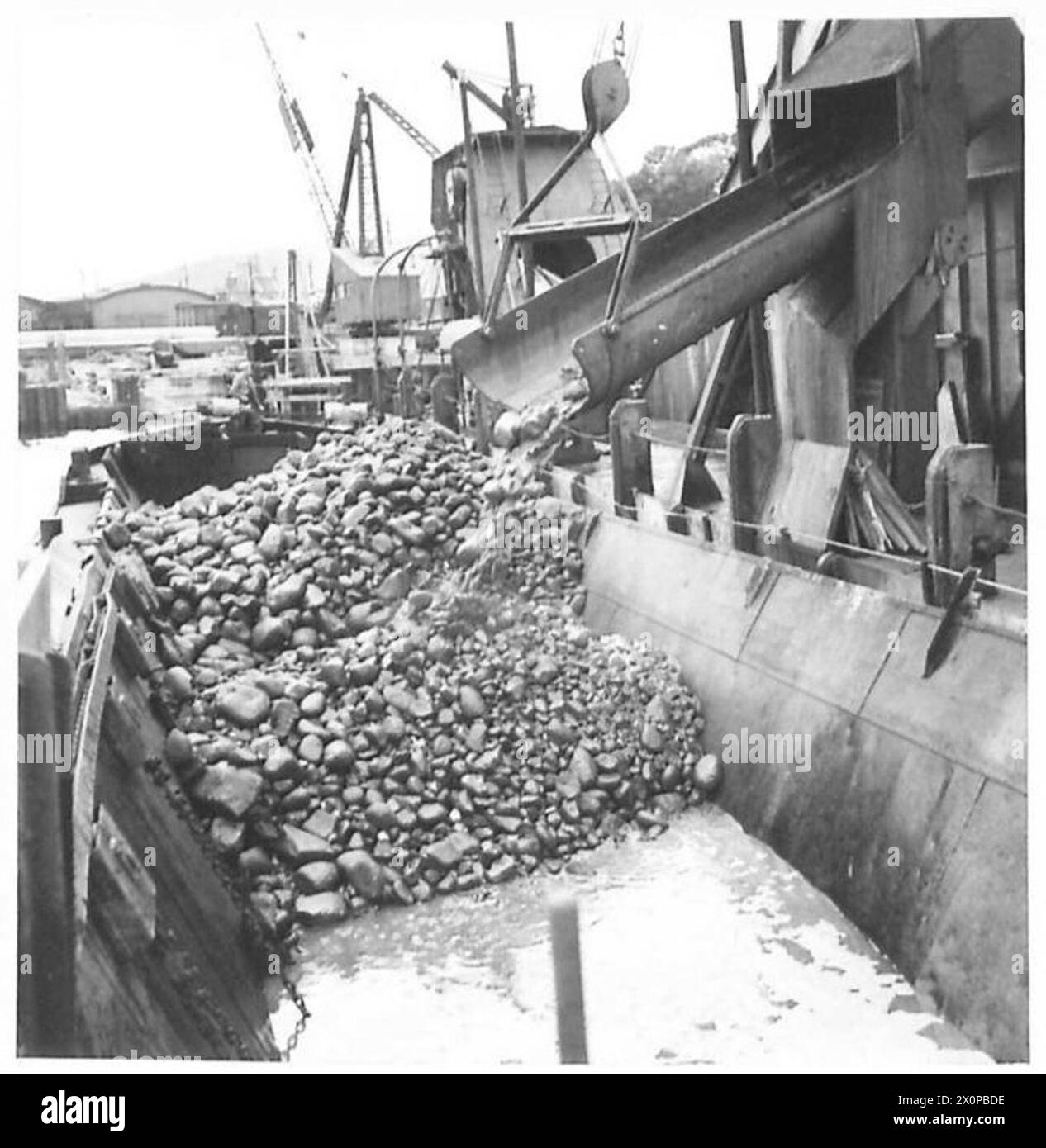 A dredger barge operates on Larne Jetty, demonstrating the type of ...
