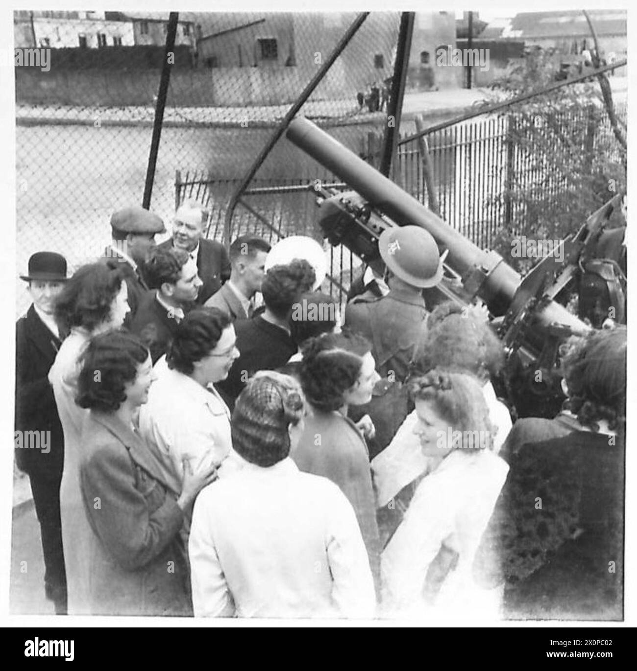 Factory workers inspect a gun they helped manufacture at a British Army ...