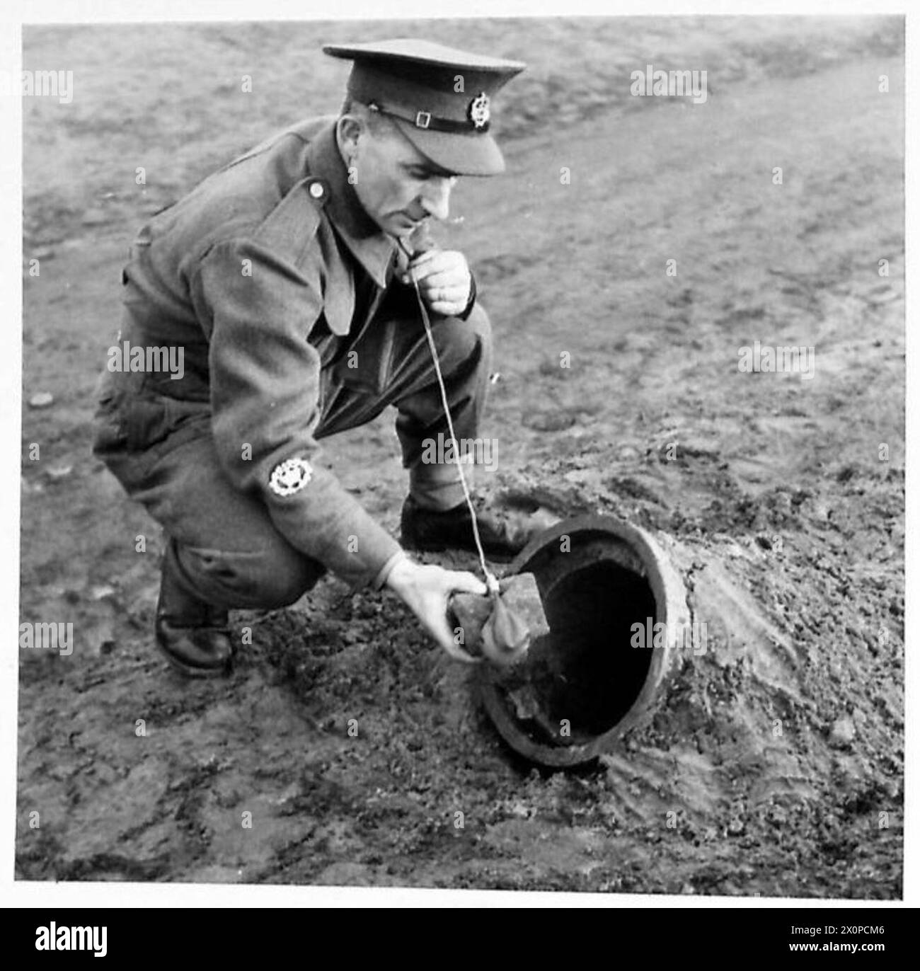 A training device simulates a Fougasse flame thrower using an ...
