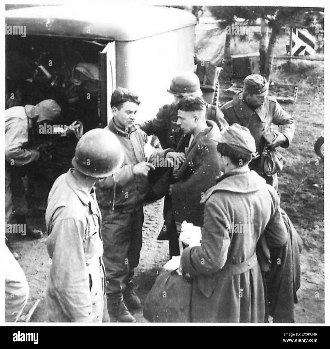 A wounded German soldier receives medical attention from American and German ambulance personnel ...