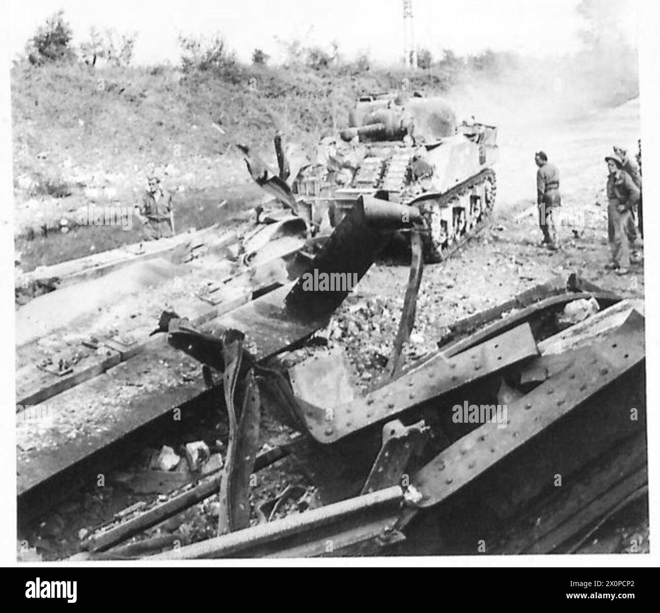 A British Army tank at the Fifth Army front in Italy tows a heavy road ...