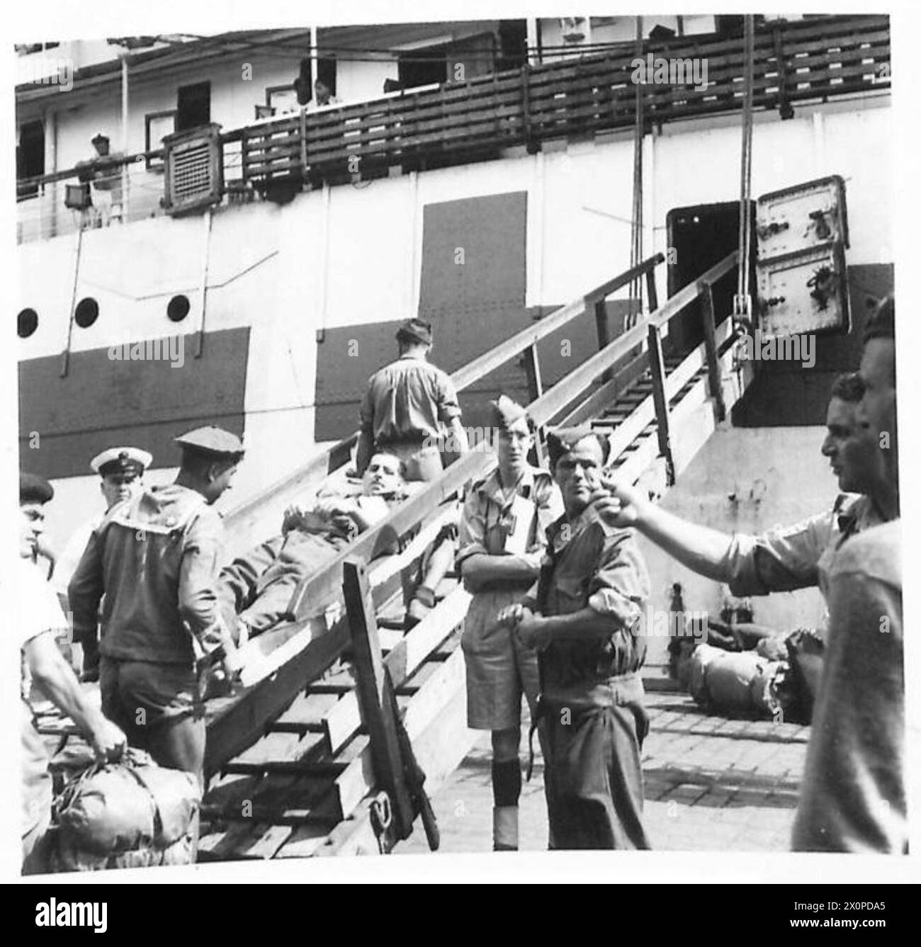 Italian prisoners of war carry a British soldier aboard a hospital ship ...