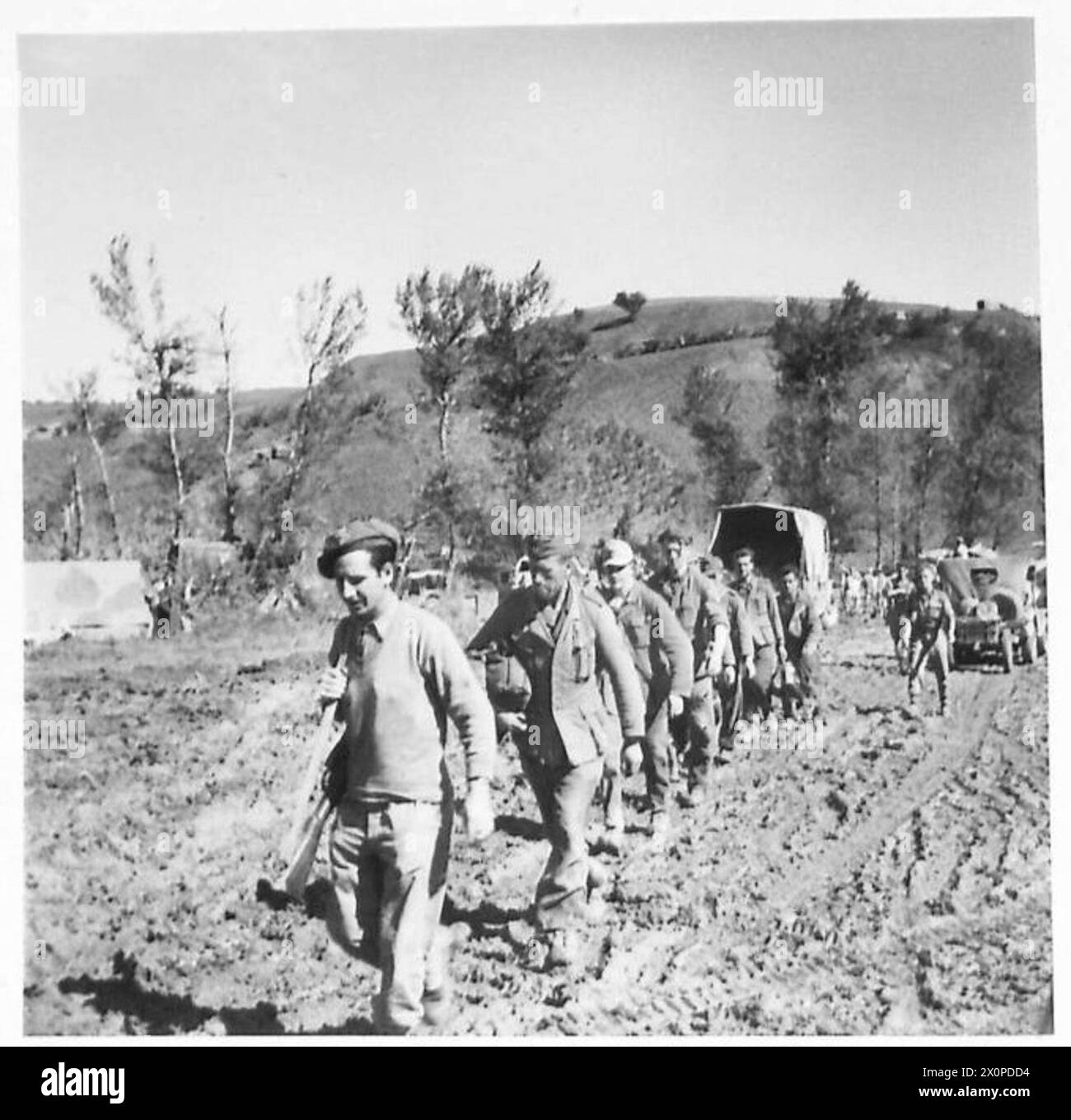 German prisoners are shown passing vehicles of the Eighth Army bogged ...