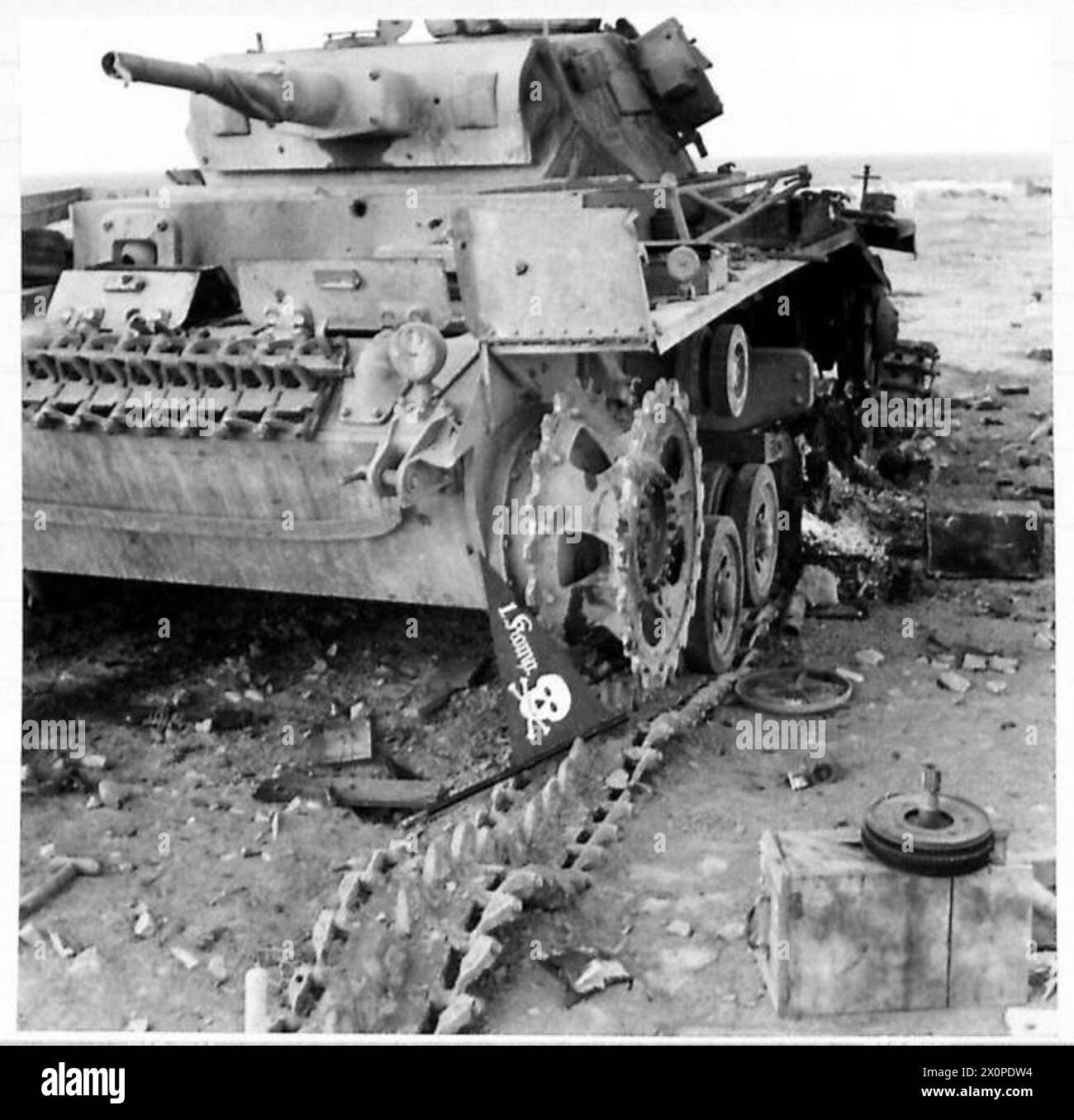 A wrecked German tank in the Western Desert displays a pennant with a ...