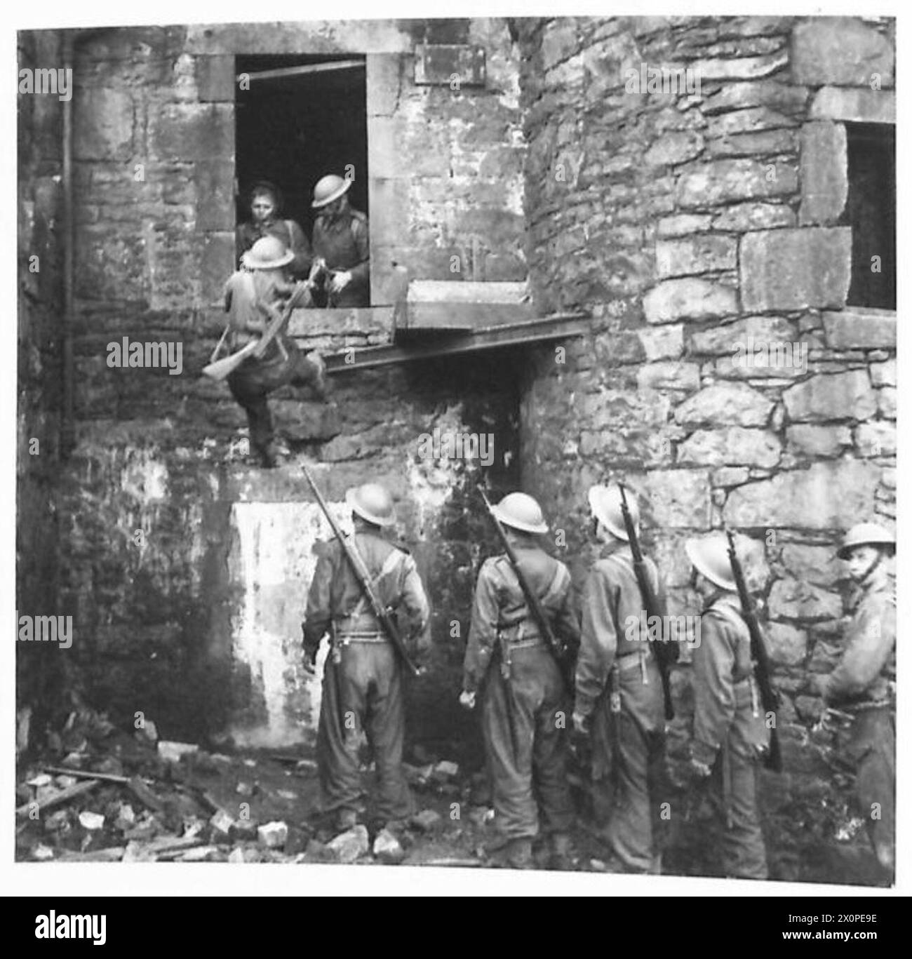 Troops are climbing the rear of a building using toggle ropes during ...