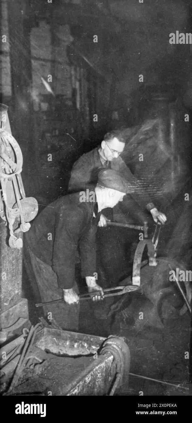 A blacksmith forges mast bands at the shipbuilding works of J Russel ...
