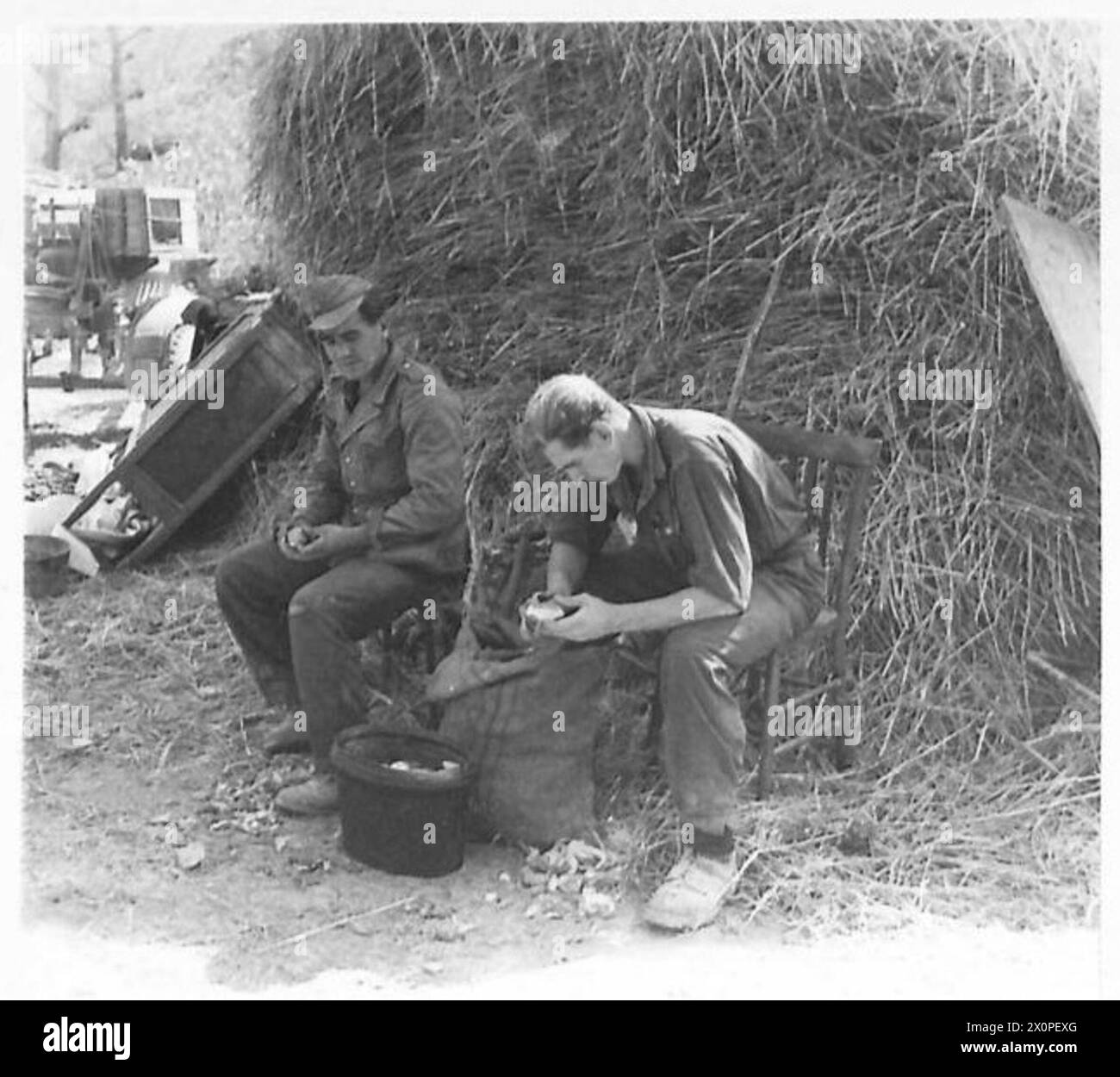 Two German prisoners held by the Eighth Army perform potato peeling ...
