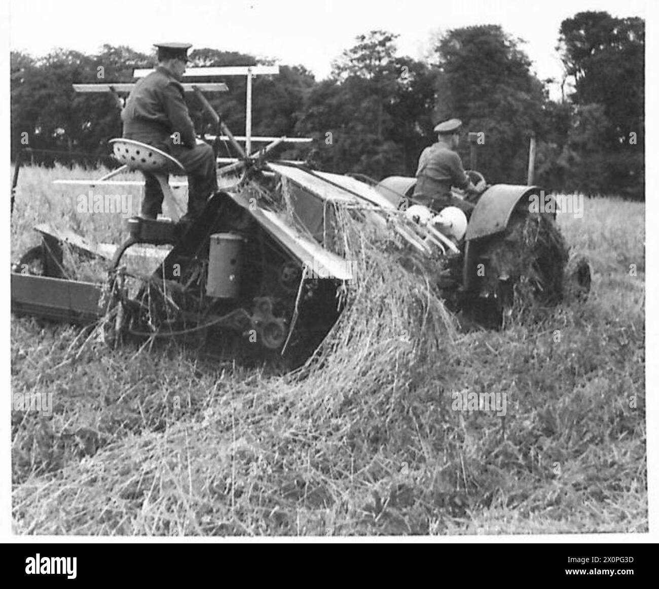 Soldiers operate a tractor and harvester to cut a ten-acre oat field ...