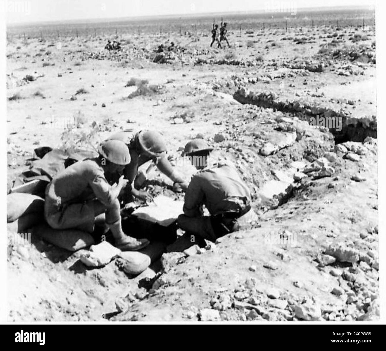 IN THE FRONT LINE - A Company Commander and his staff study a map in ...