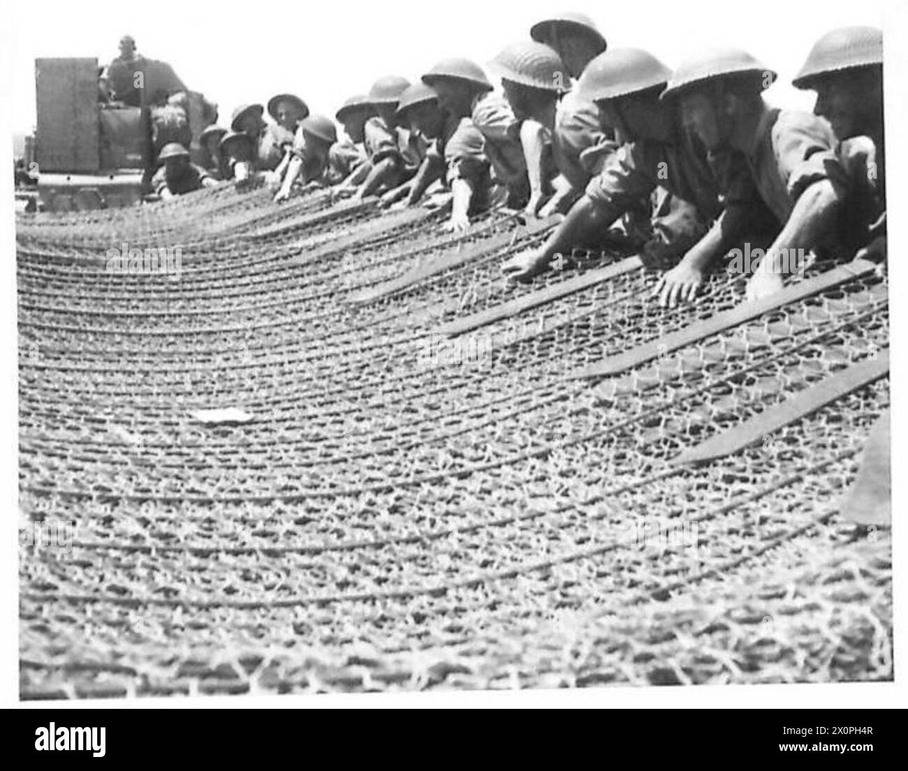 Pioneers transport and position a wire road ashore during the invasion ...