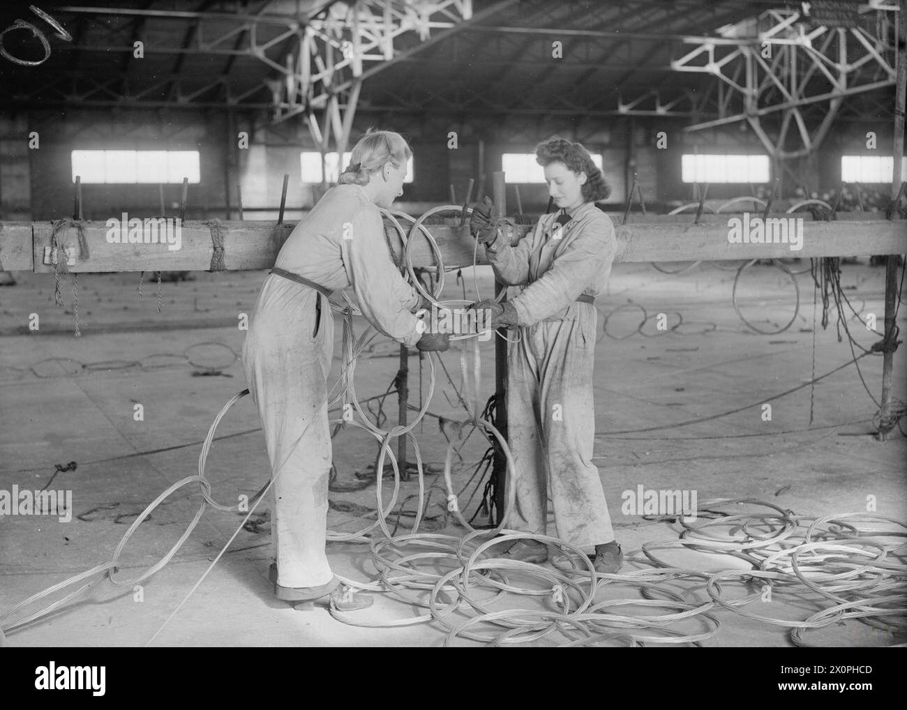 Women work on reeving grommets for boom defence nets at Southampton on ...