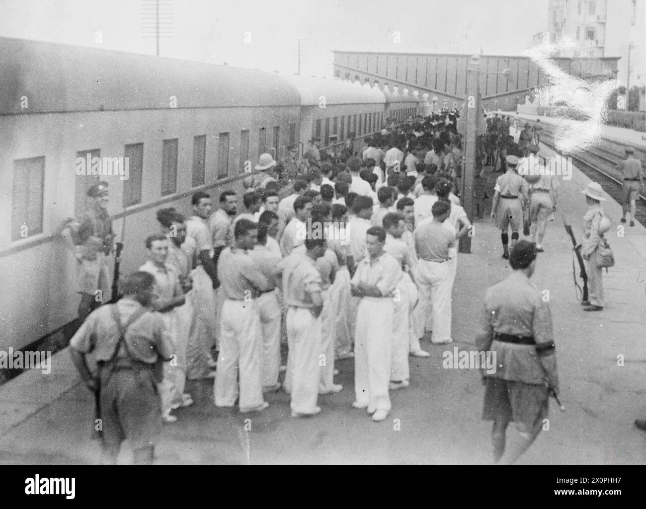 Italian prisoners are held under guard before boarding a train during ...