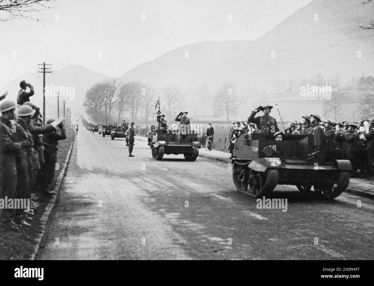 Universal Carriers of the 1st Polish Corps pass a saluting base during ...