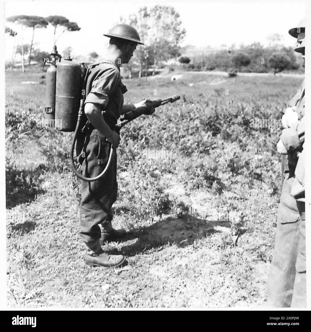 BRITISH USE AMERICAN PORTABLE FLAME-THROWER - One of the men ...