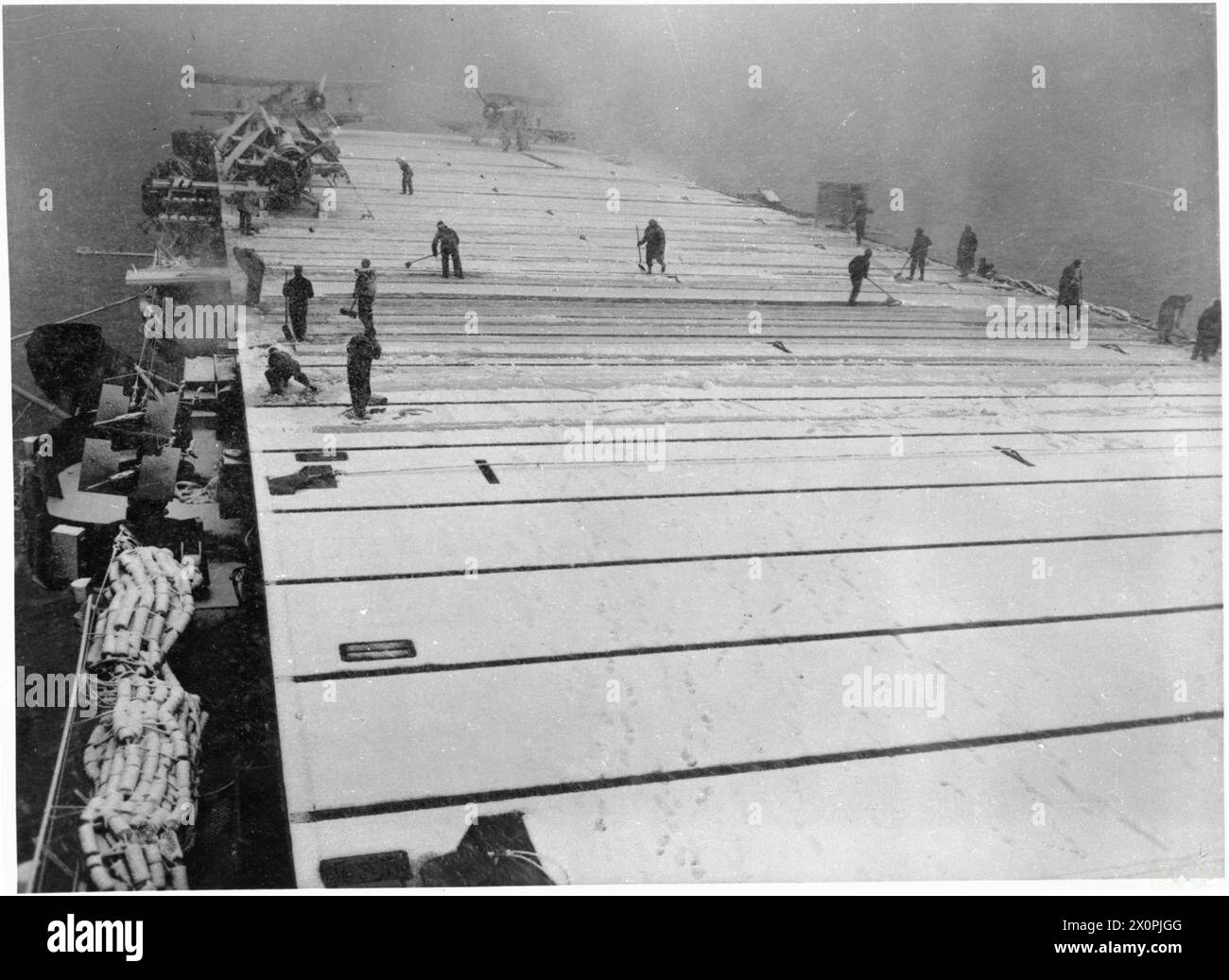 On HMS Fencer, snow is cleared from the flight deck to maintain ...