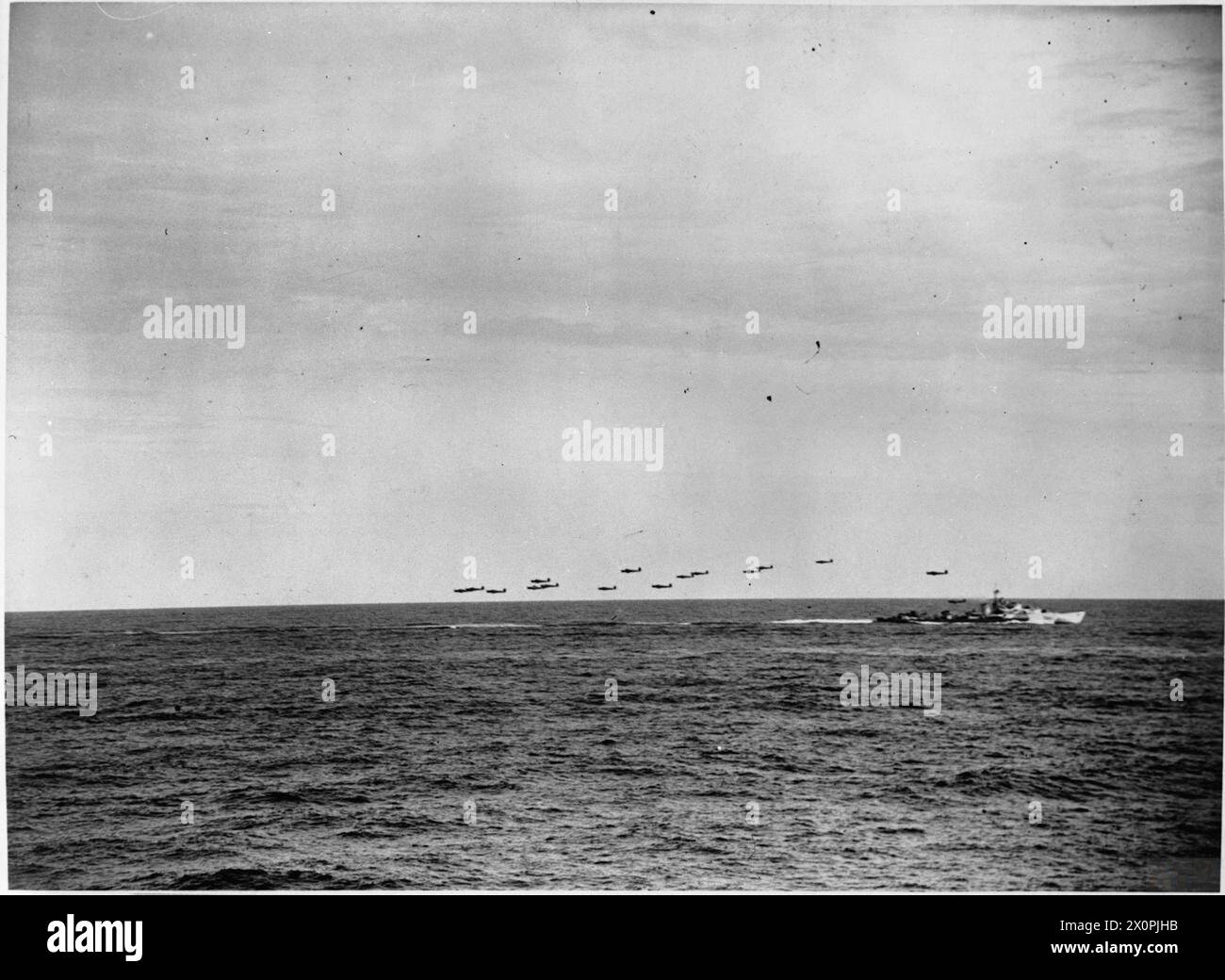 Fleet Air Arm aircraft fly low over the sea toward enemy targets in ...