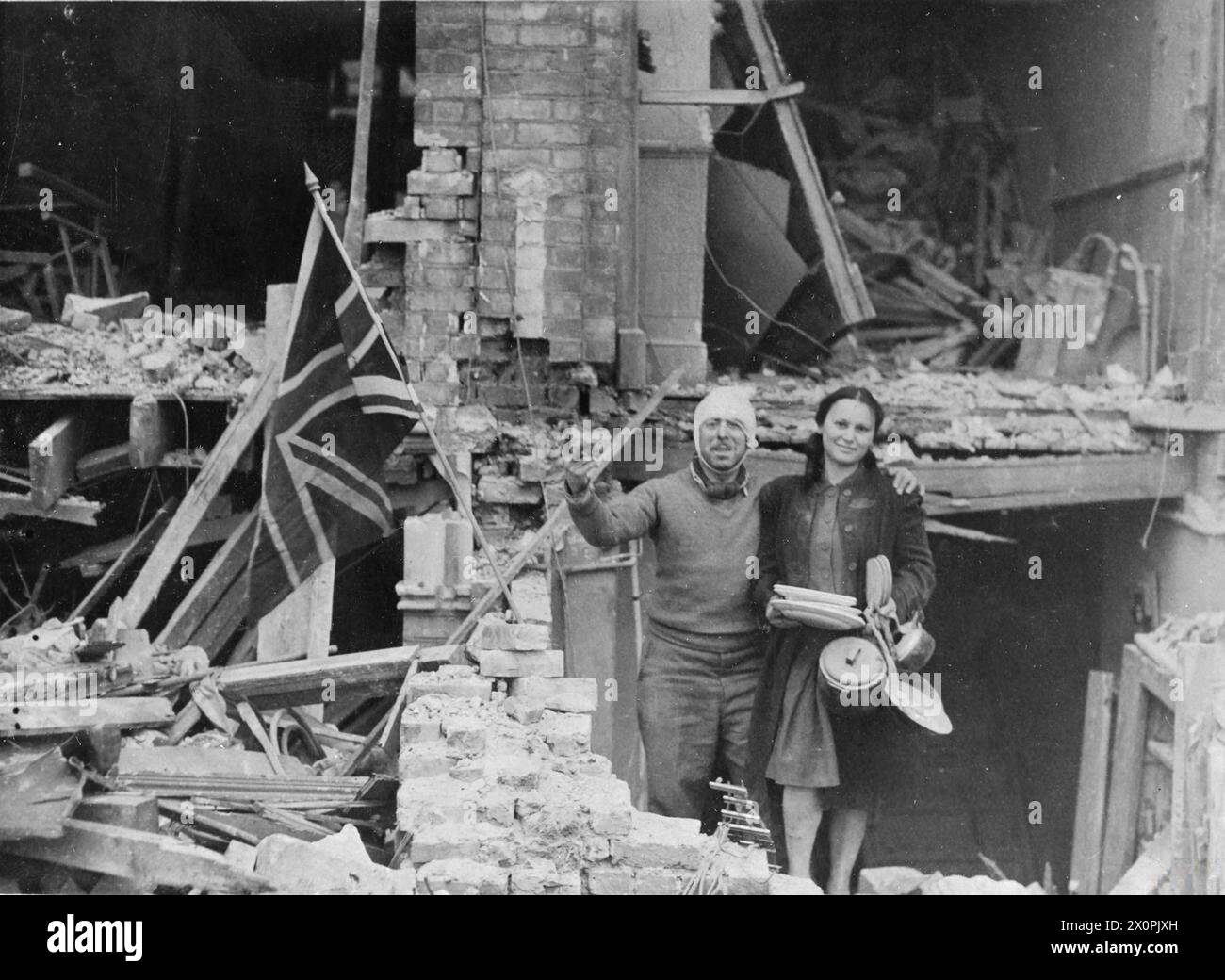 BOMB DAMAGE: 1944 - couple with salvage and union jack flag in front of ...
