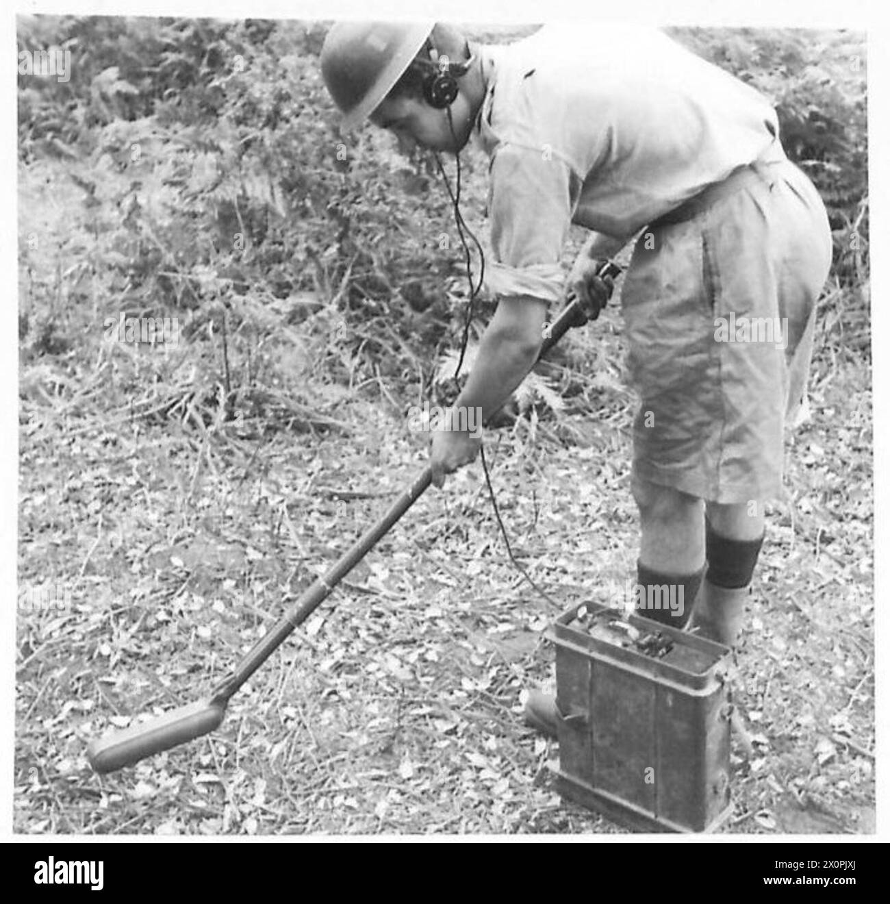 A mine detector with an extension allows the operator to stand while ...