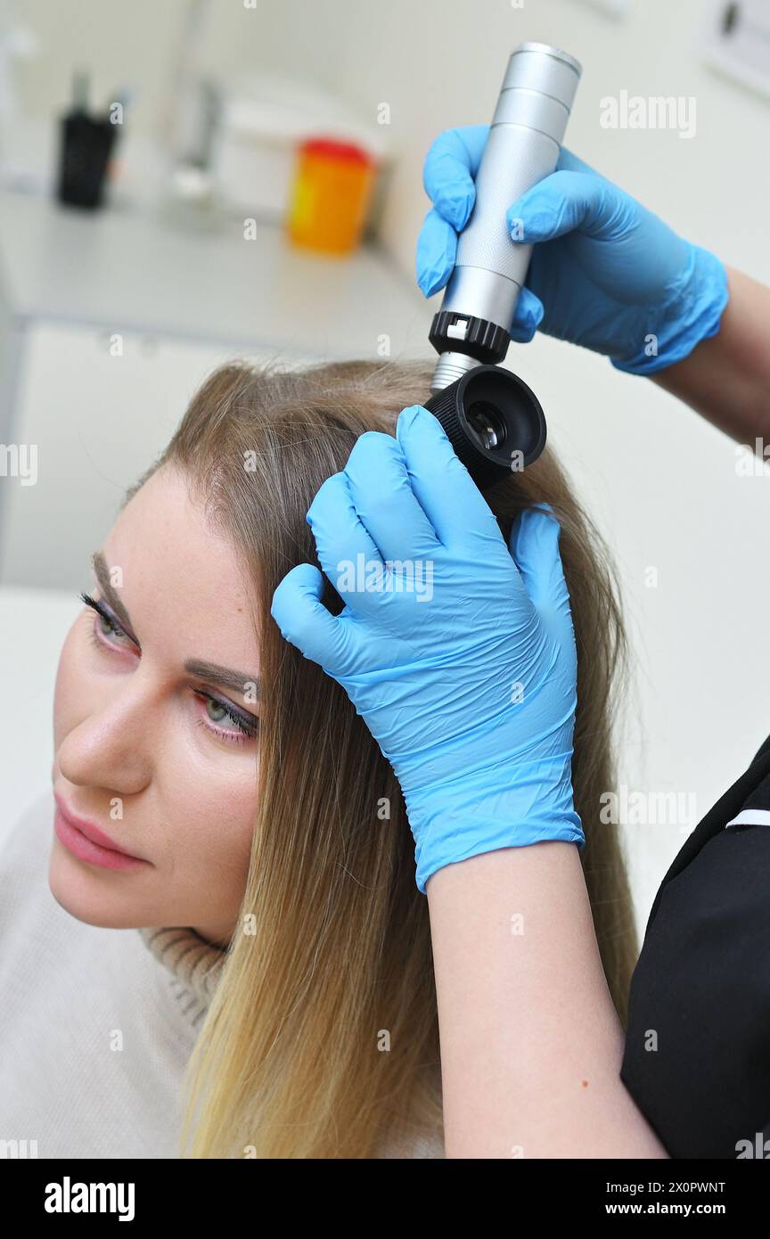 dermatologist holds a dermatoscope in his hands and examines the ...