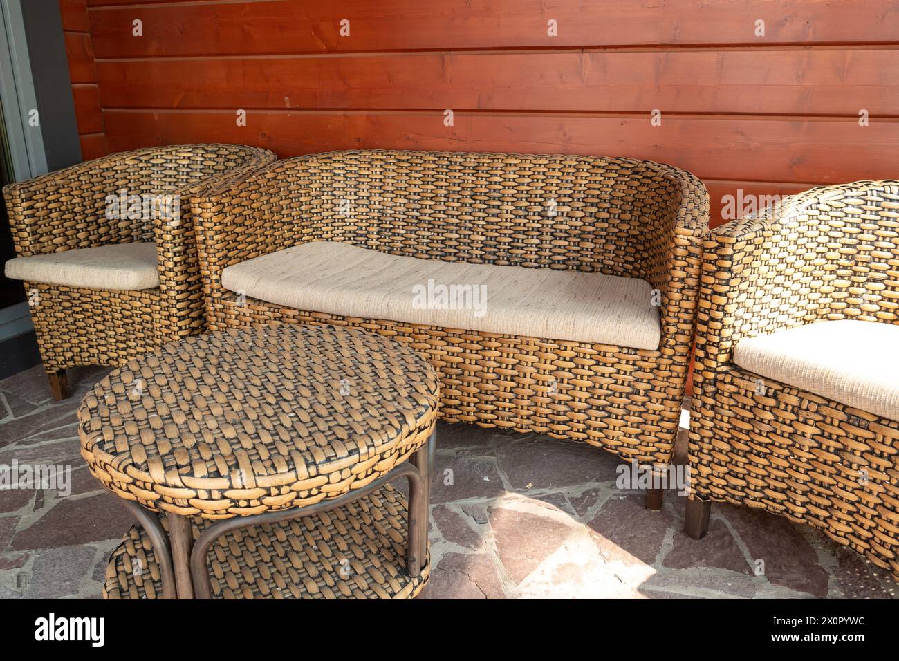 A cozy outdoor seating area featuring a stylish wicker sofa set, a ...