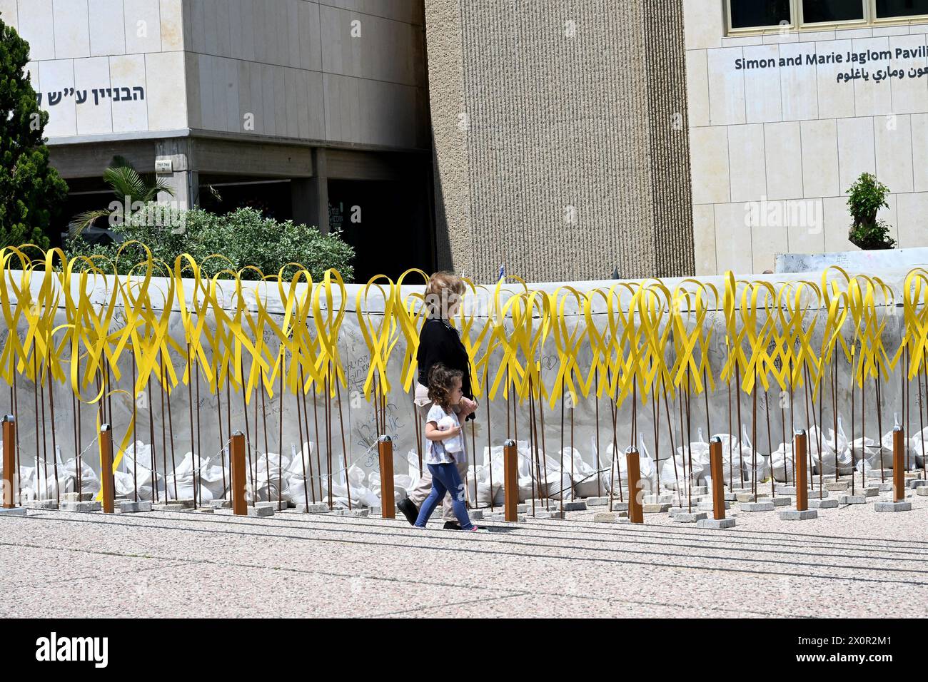 Tel Aviv, Israel. 13th Apr, 2024. A woman walks with a child past ...