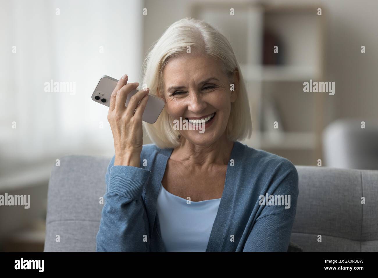 Mature woman listening voice message hi-res stock photography and ...