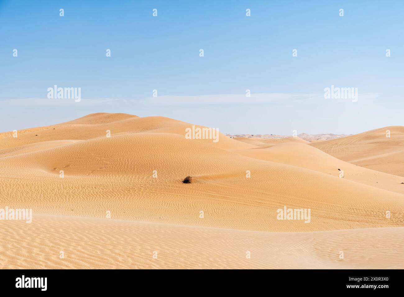 Wide desert sand dune with hills and blue sky. Wavy sand patterns ...