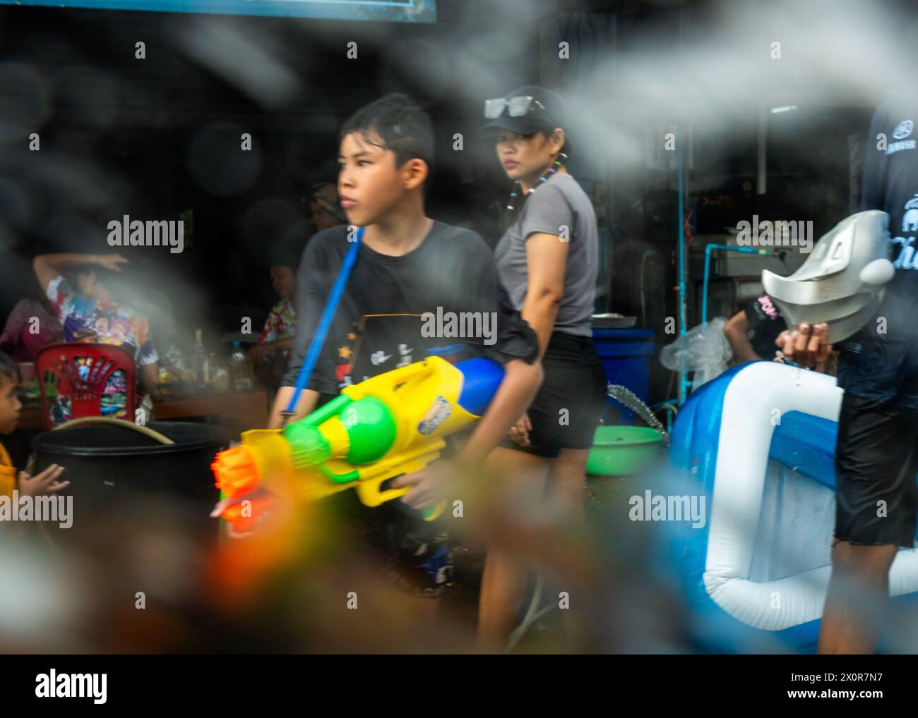 A Thai teenager is seen playing with a water gun during the Songkran ...